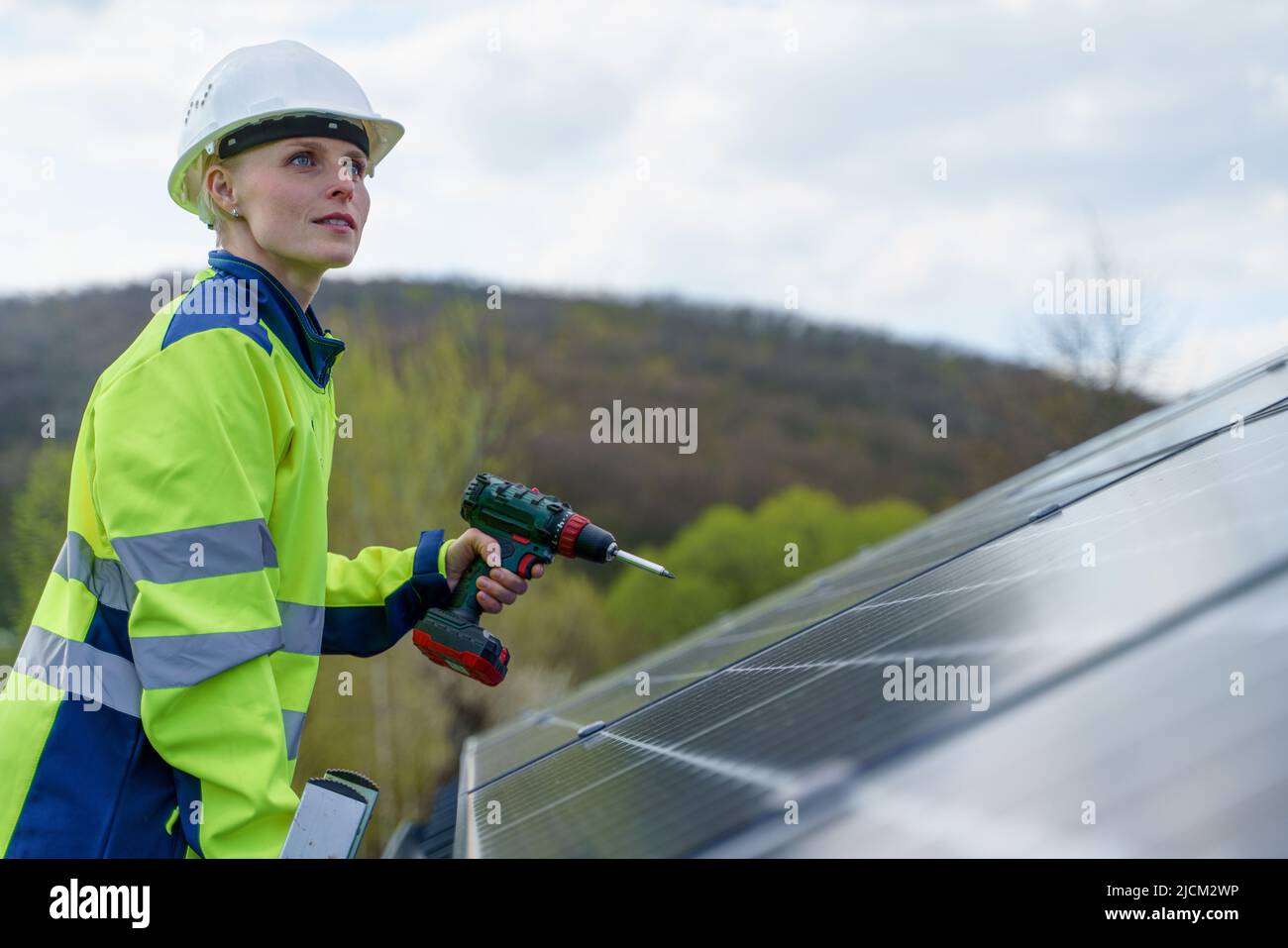 Woman engineer installing solar photovoltaic panels on roof ...