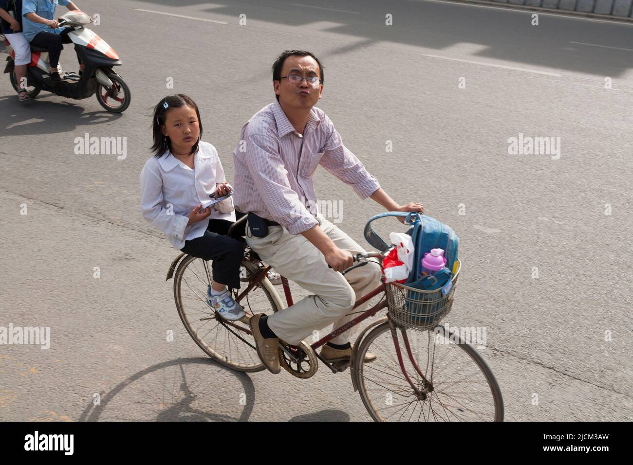 Cycling dad / father rides his bike with girl / daughter as pillion ...
