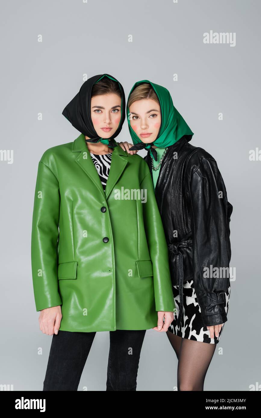 women in green and black jackets and kerchiefs looking at camera ...