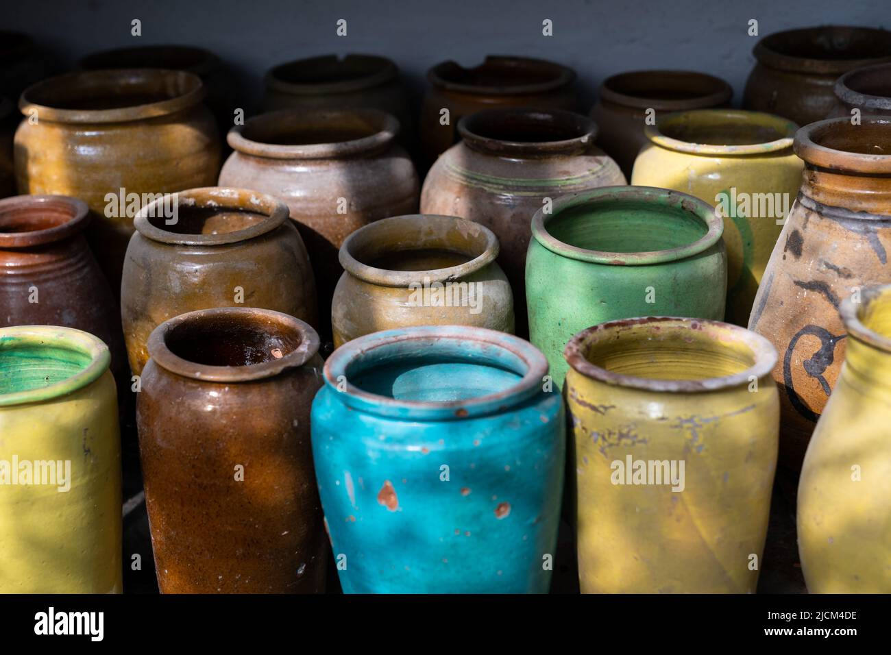 Many unique handmade colorful clay jugs and vases of various shapes on ...