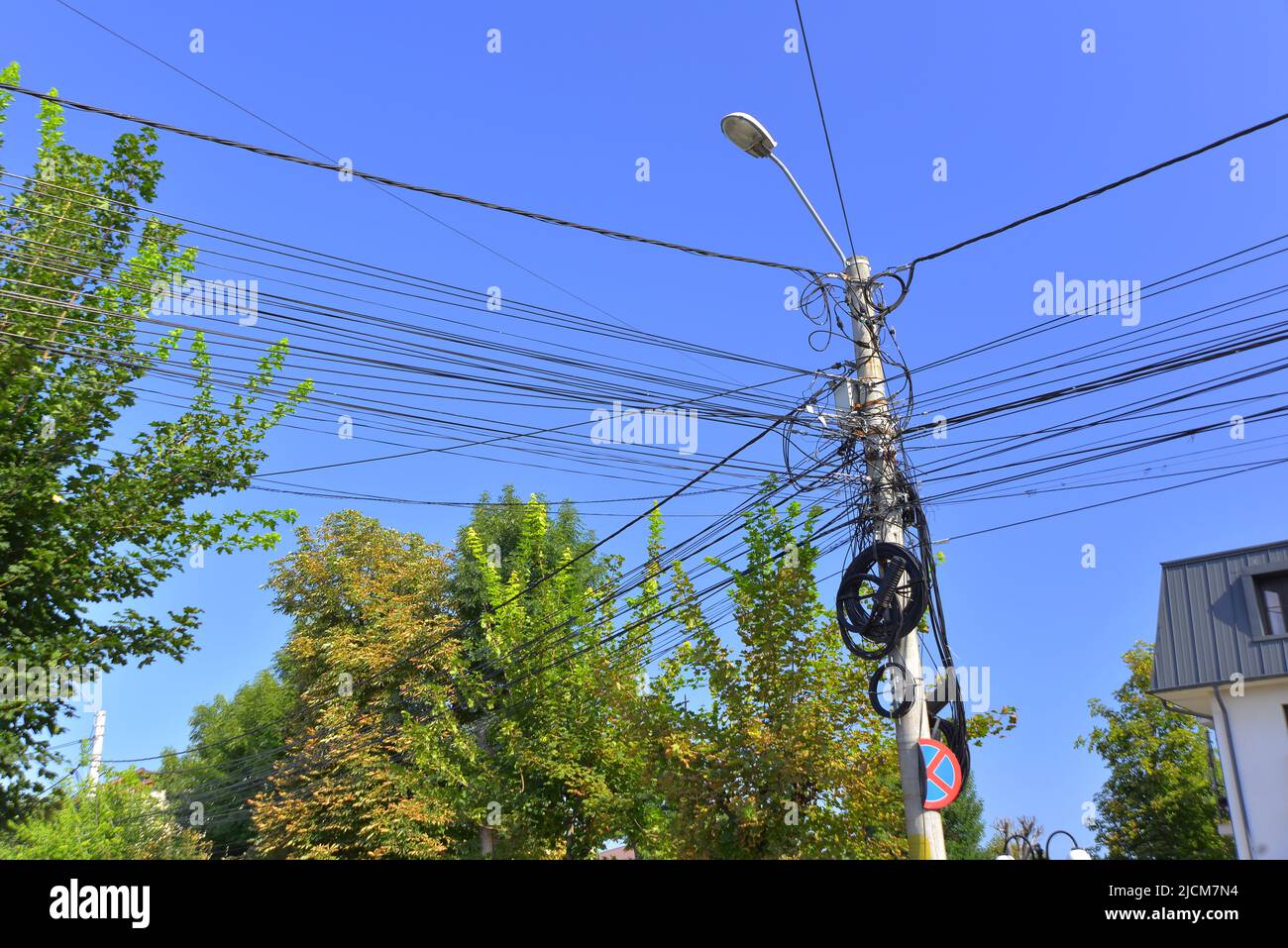 Pole overloaded with communication cables Stock Photo - Alamy