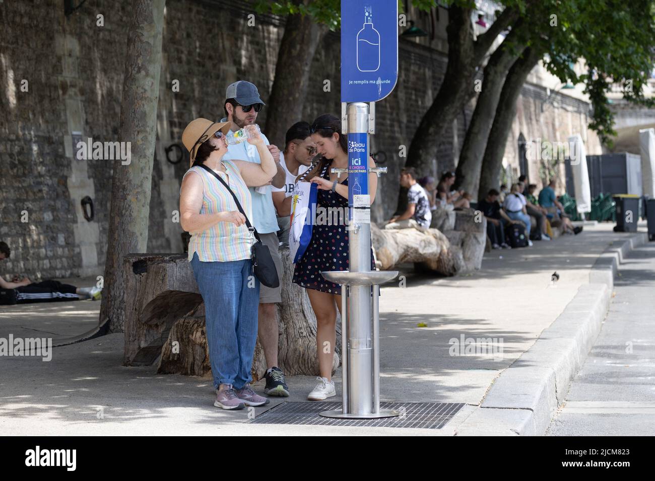 Paris, France, June 14, 2022. People drink water from a plastic bottle ...