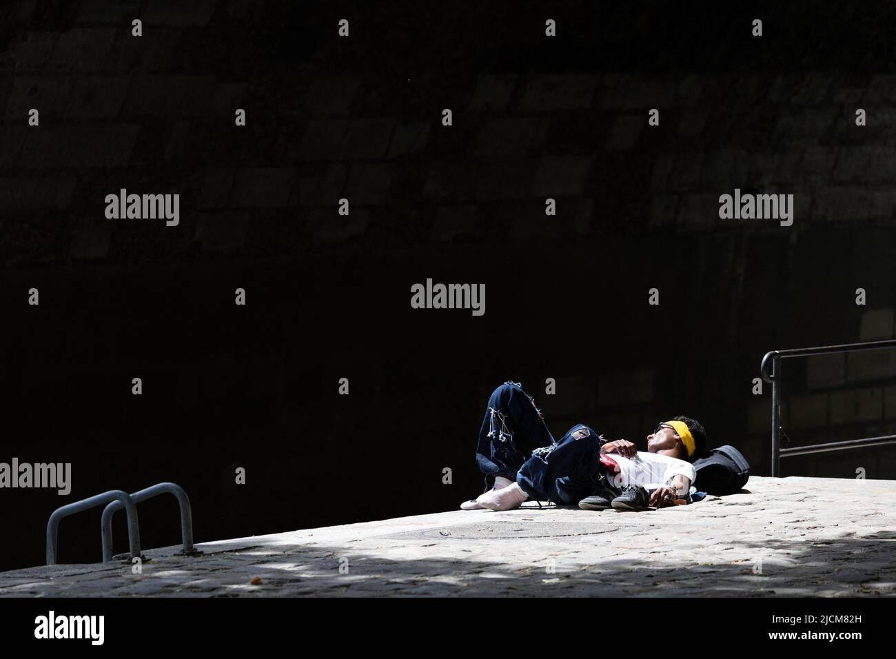 Paris, France, June 14, 2022. People sit in the sun near the Seine ...