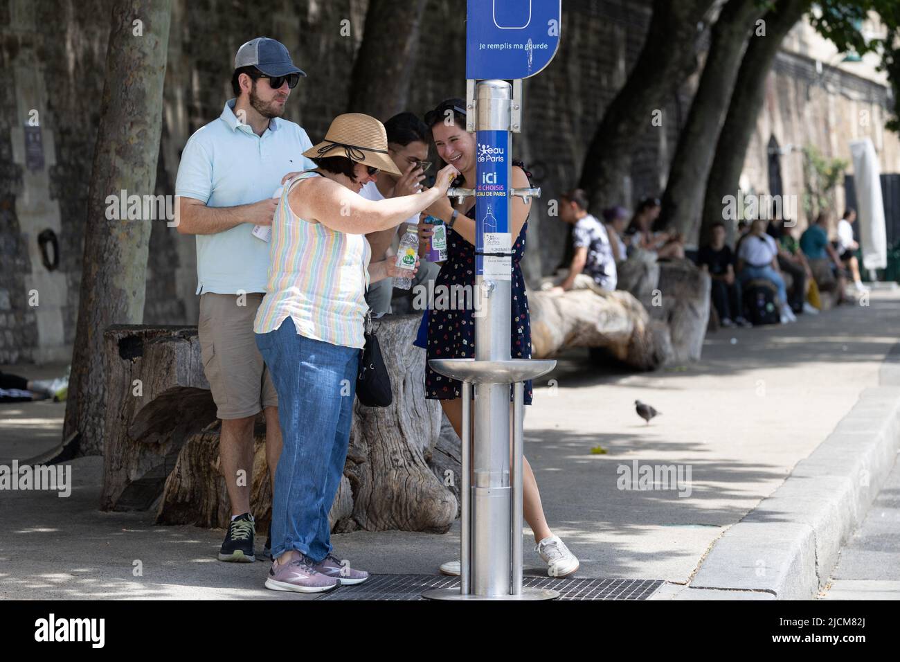 Paris, France, June 14, 2022. People drink water from a plastic bottle ...