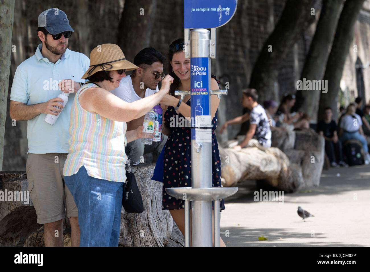 Paris, France, June 14, 2022. People drink water from a plastic bottle ...