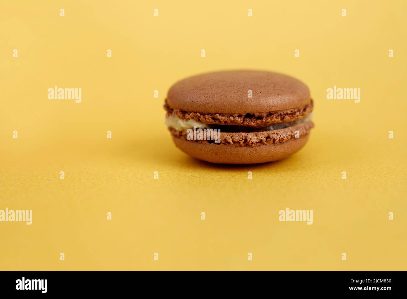 Chocolate macaron, french dessert made from egg whites, on a golden ...