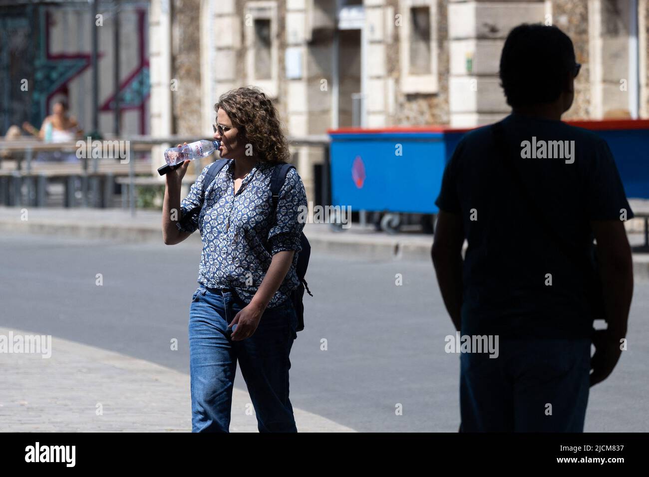 Paris, France, June 14, 2022. People drink water from a plastic bottle ...