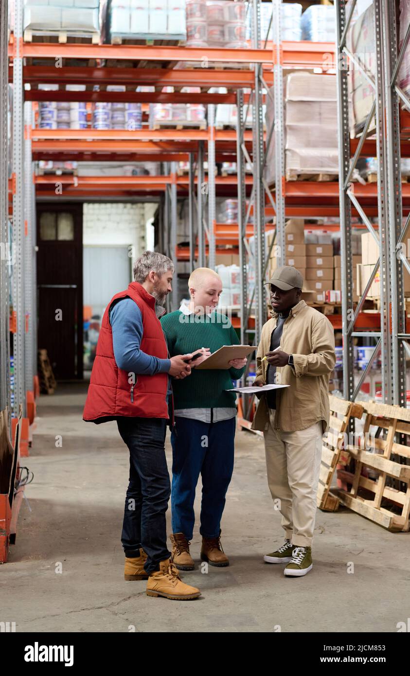 Warehouse workers discussing shipping with supervisor during their work ...