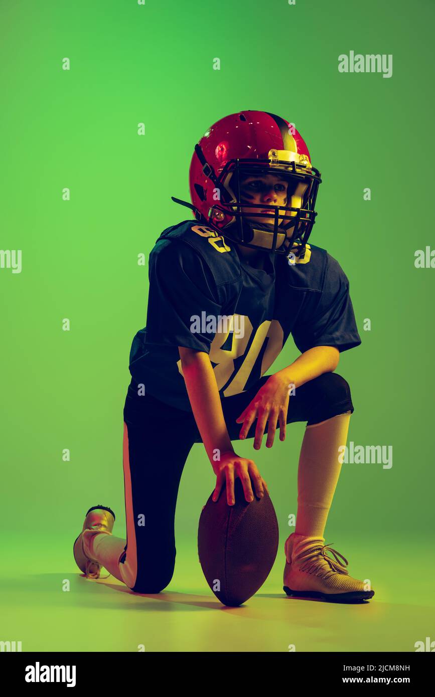 Athletic kid, beginner american football player in sports uniform and ...
