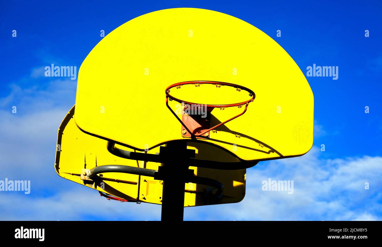 Basketball hoop with yellow backboard for competition sports blue sky ...