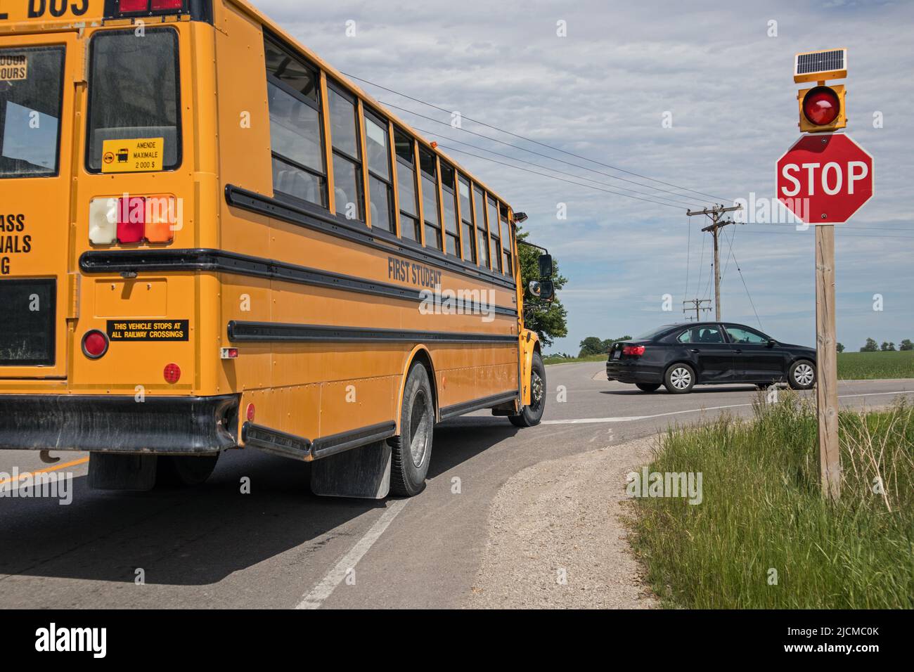 STOP signage with red light flashing, yellow school bus at the ...