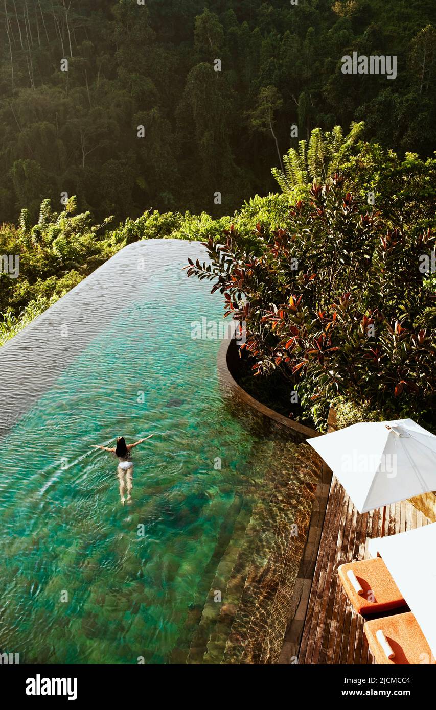 Woman swimming in infinity pool, Ubud Hanging Gardens, Bali, Indonesia ...