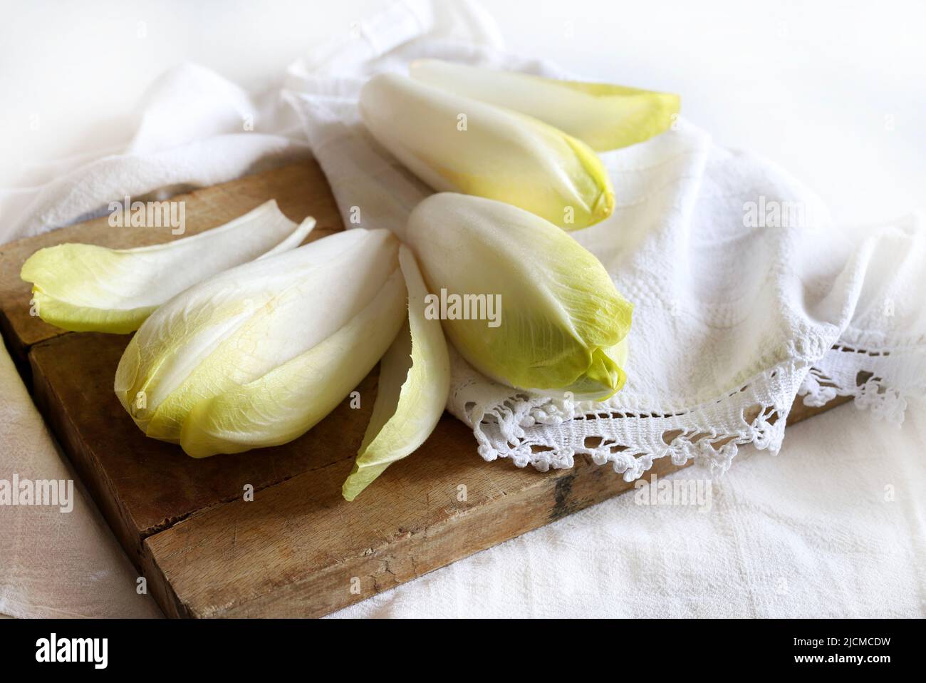 Group of raw endives on a wooden background Stock Photo - Alamy