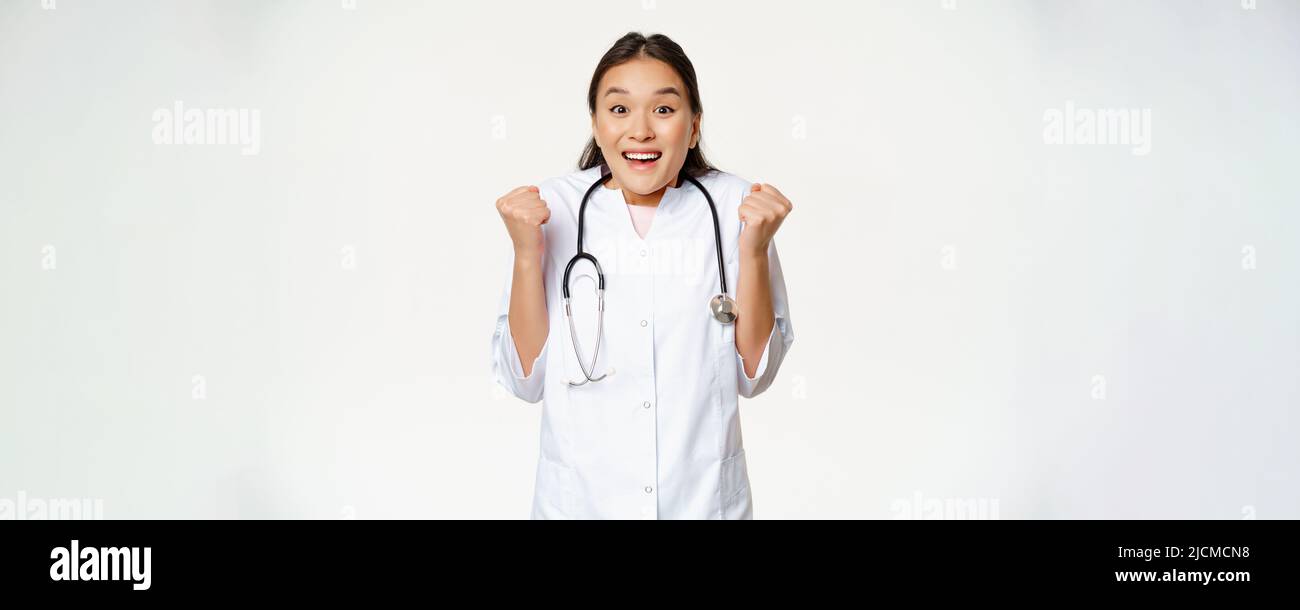 Enthusiastic female asian doctor celebrating, looking hopeful and happy ...
