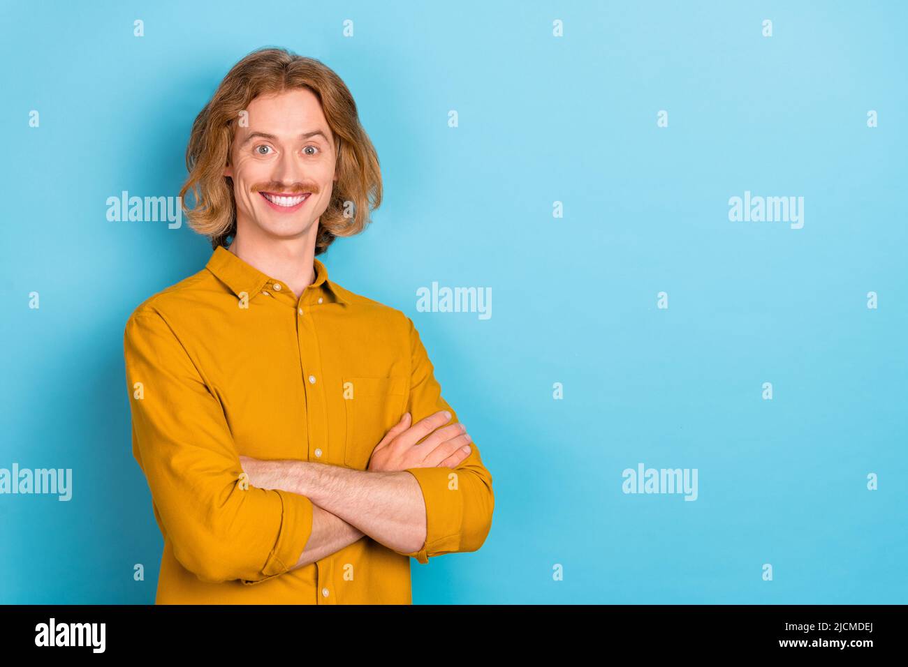 Portrait of attractive cheerful long-haired guy folded arms copy space ...