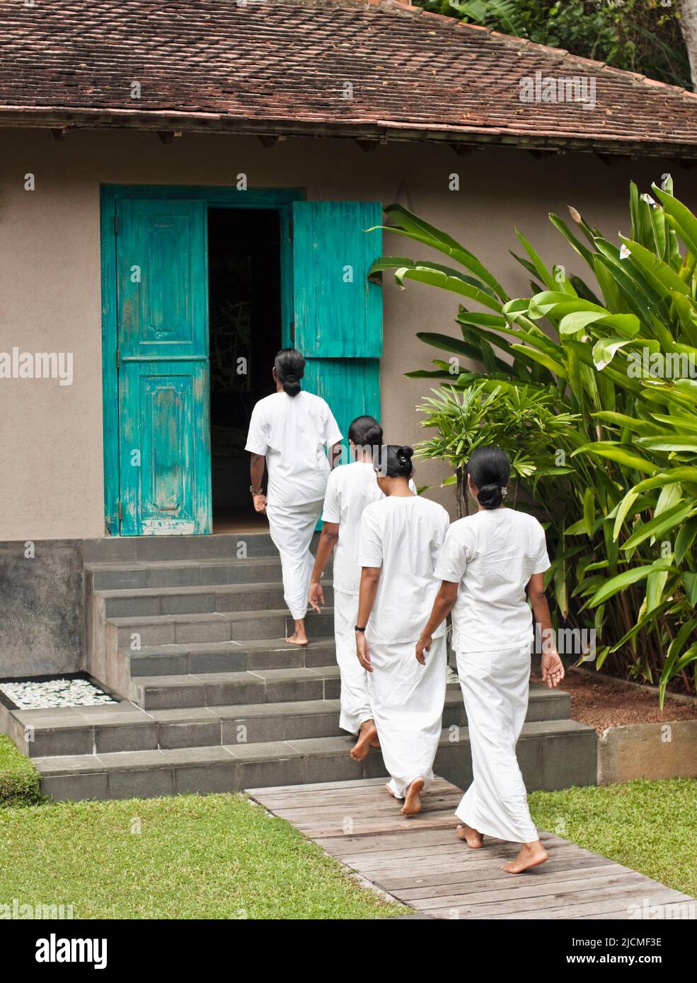 A group of female spa therapists walk to a spa treatment room ...