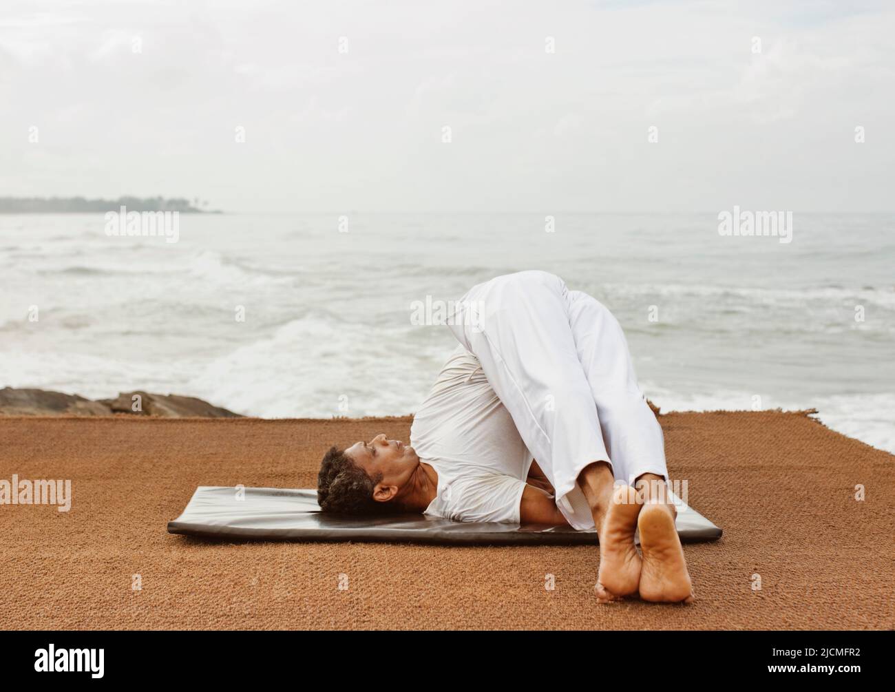 Sri Lankan yoga master practices yoga by the beach. Aturuwella, Bentota ...