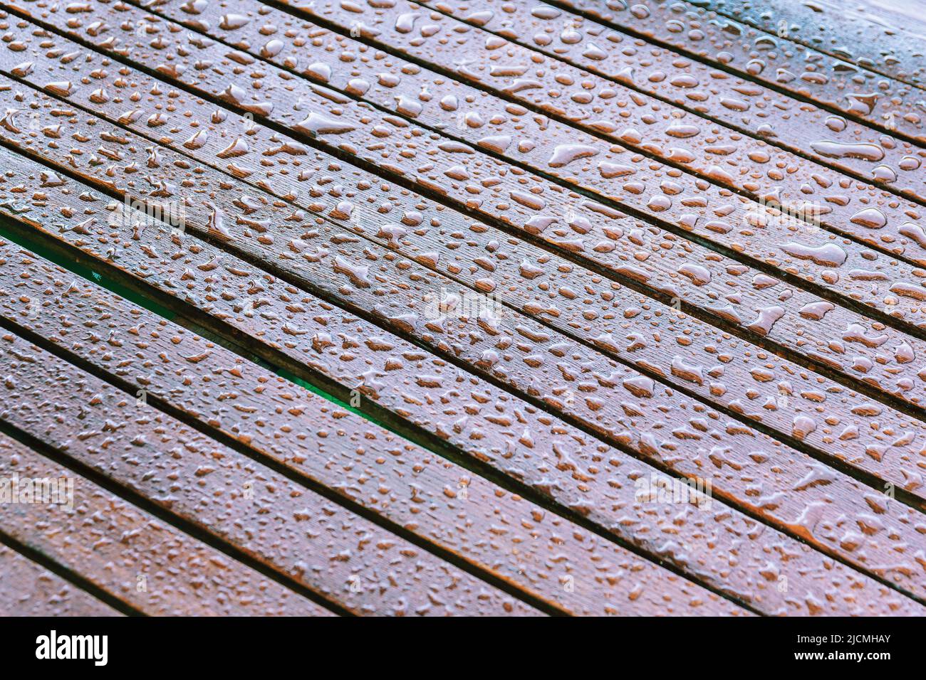 the surface of a wooden plank table is covered with small drops of ...