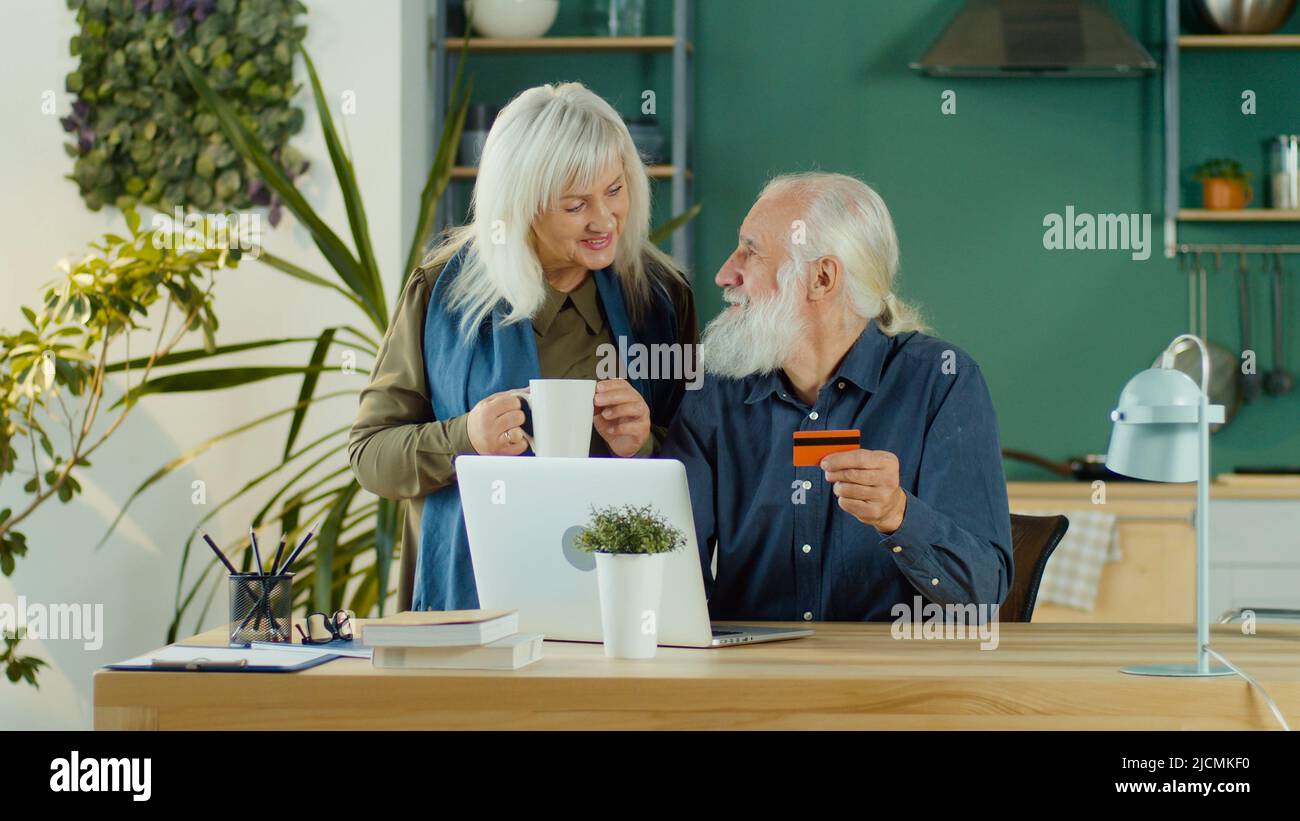 Happy older couple using computer tablet together at home hi-res stock ...