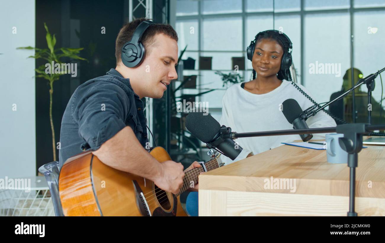An Influential Musician Sings and Plays the Guitar During a Radio ...