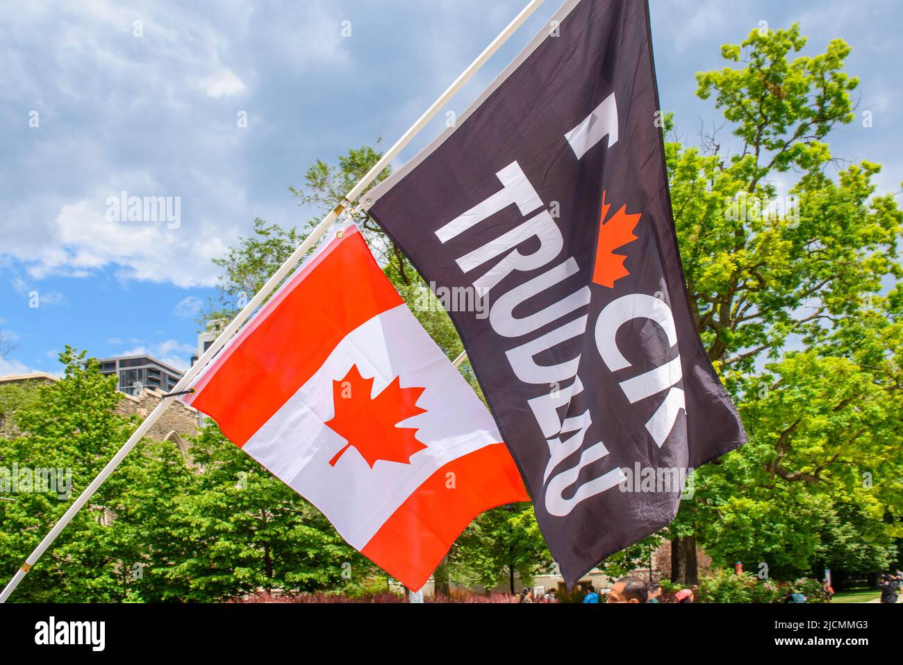 A Canadian national flag and a Fuck Trudeau flag are together in a pole ...