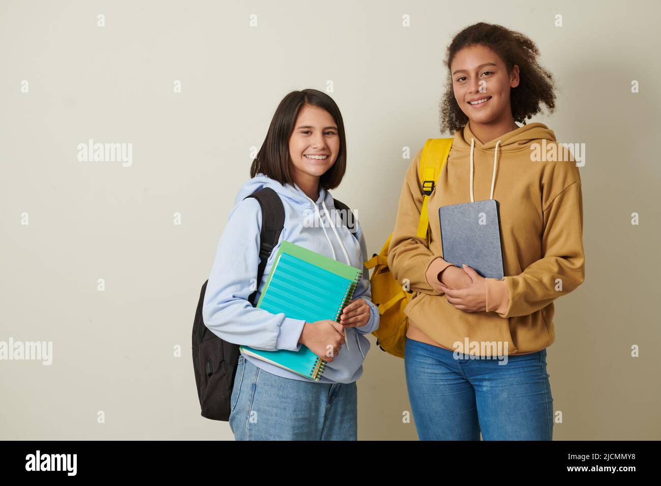 Portrait of happy college students with text books and tablet smiling ...