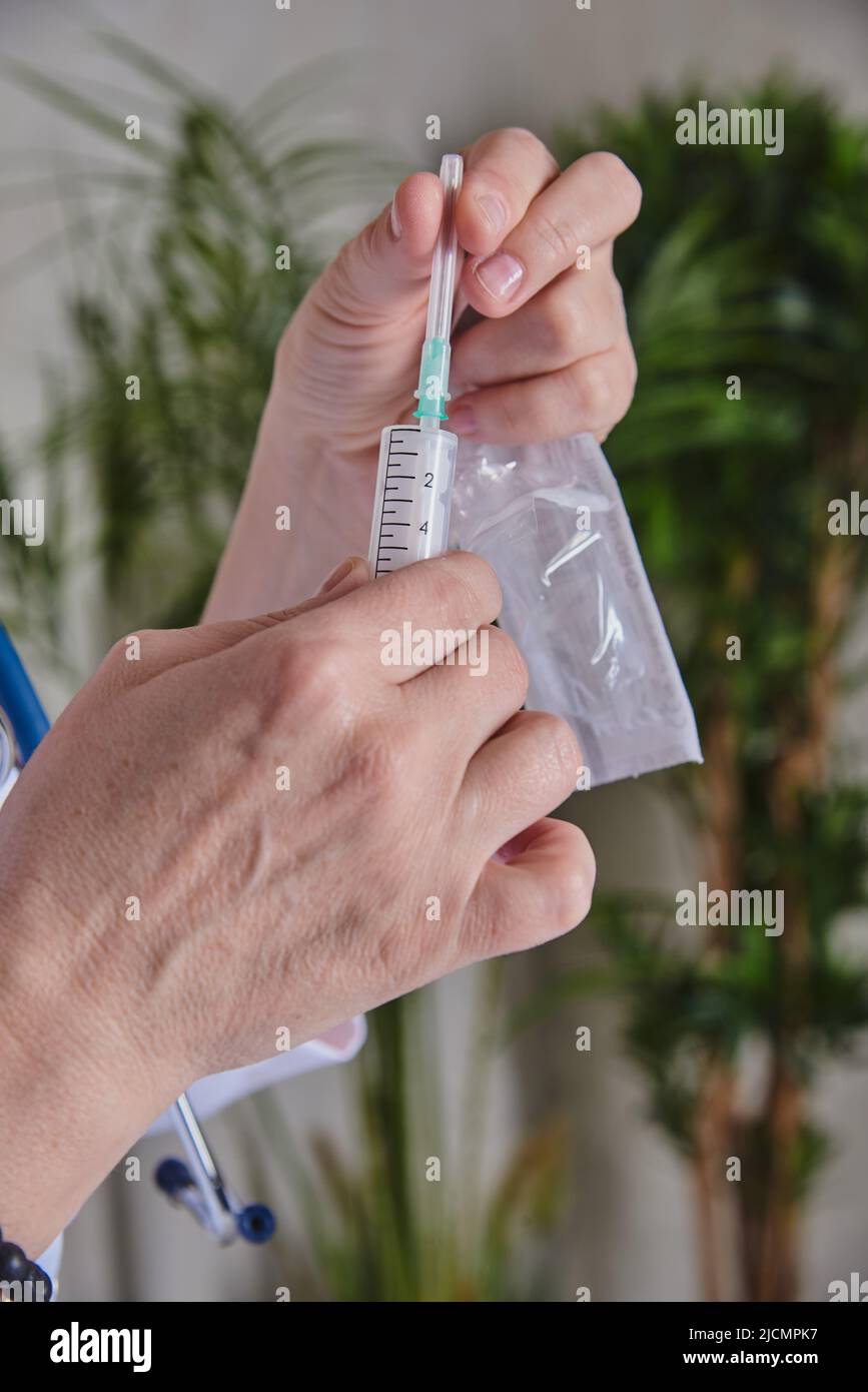 A female doctor takes a new syringe out of the package.about Stock ...