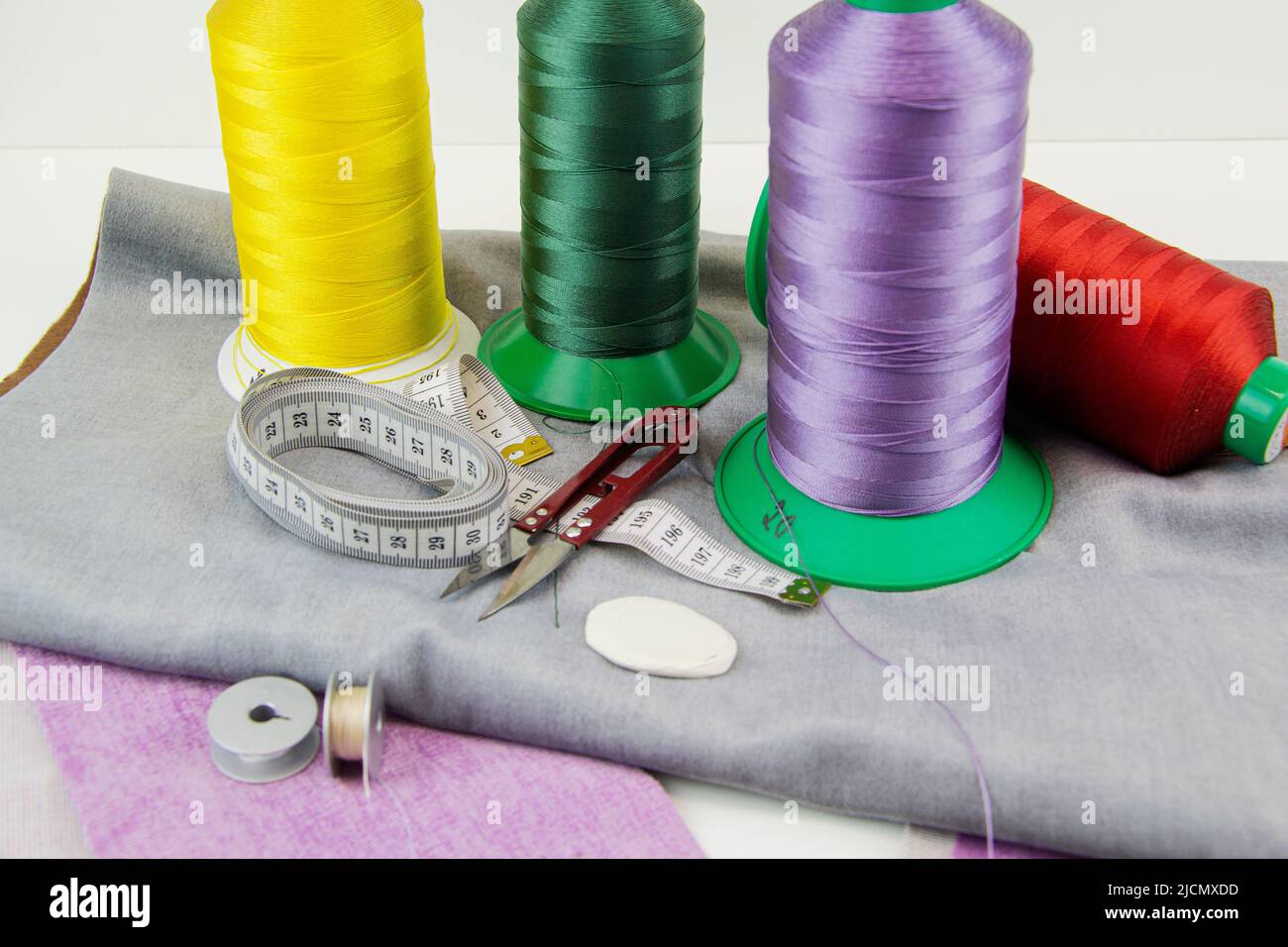Colorful sewing threads, tailor's scissors and measuring tape in the ...
