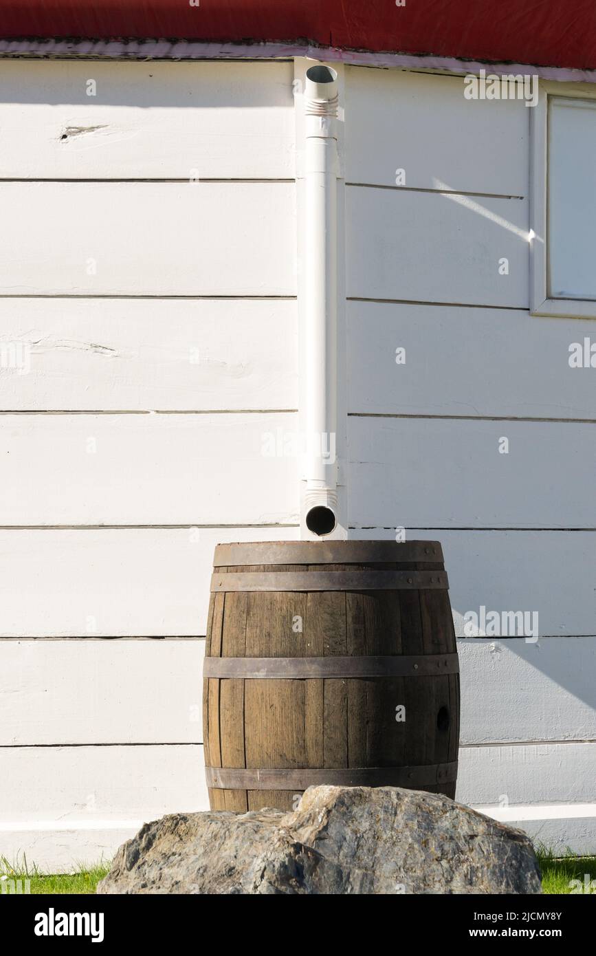 "Wooden barrel in front of a pipe, coming down from a white striped ...