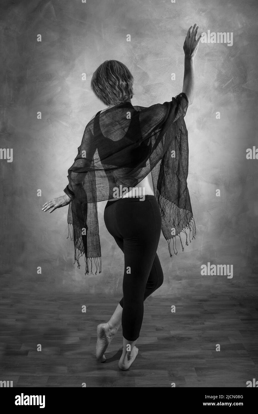 A woman from the back dressed in black is dancing Stock Photo - Alamy