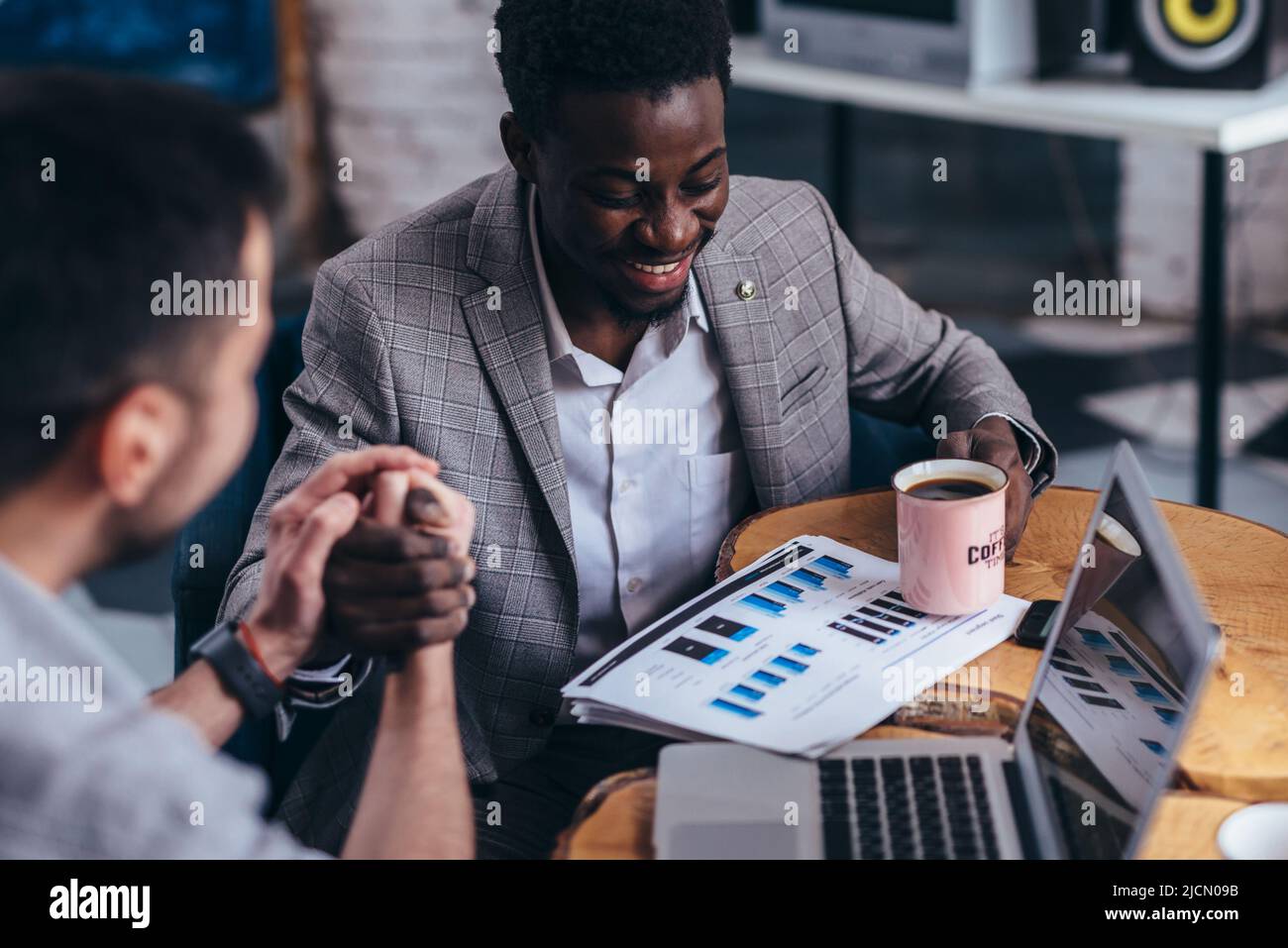 Two Businessmen Having Meeting Around Table In Cafe Stock Photo - Alamy
