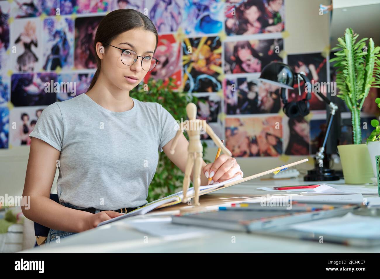 Teenage creative girl artist drawing with a pencil, sitting at the ...