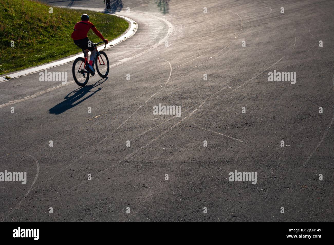 Cyclist training on the cycle-racing track at sunset. Healthy lifestyle ...