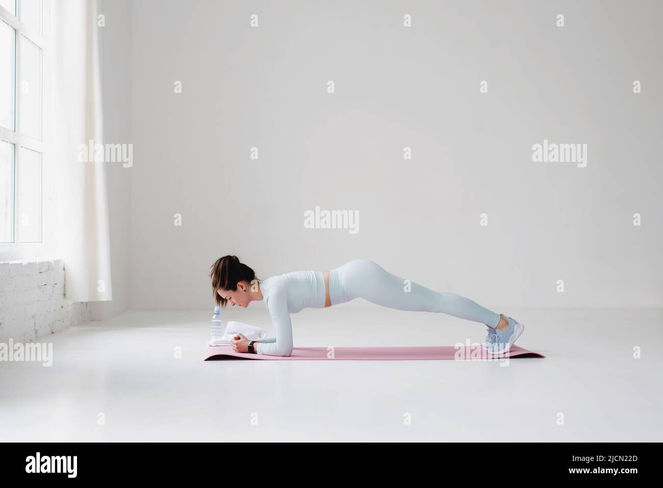 Fitness woman in plank position at white background Stock Photo - Alamy