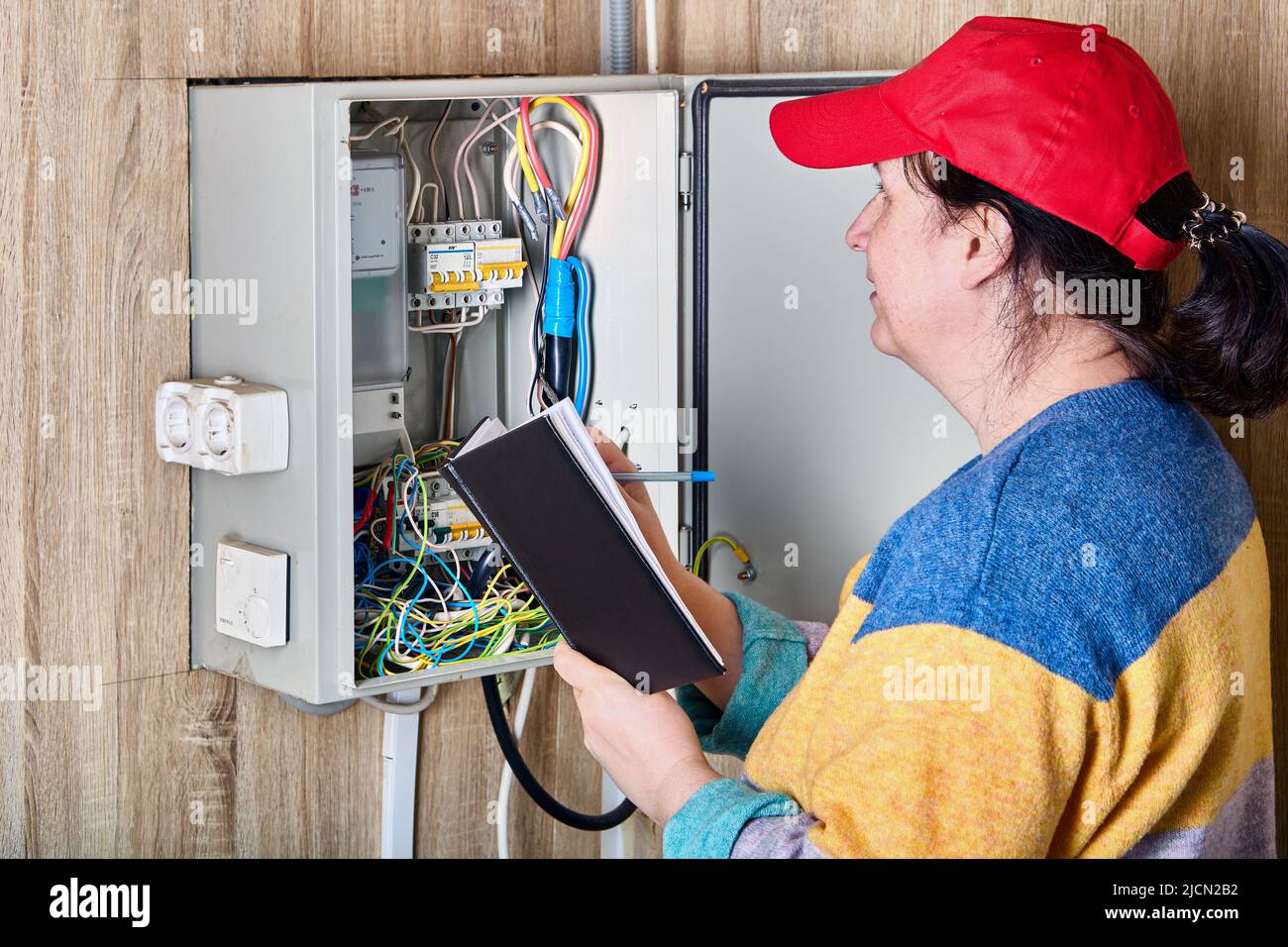 Taking readings from electricity meter by female electrician Stock ...
