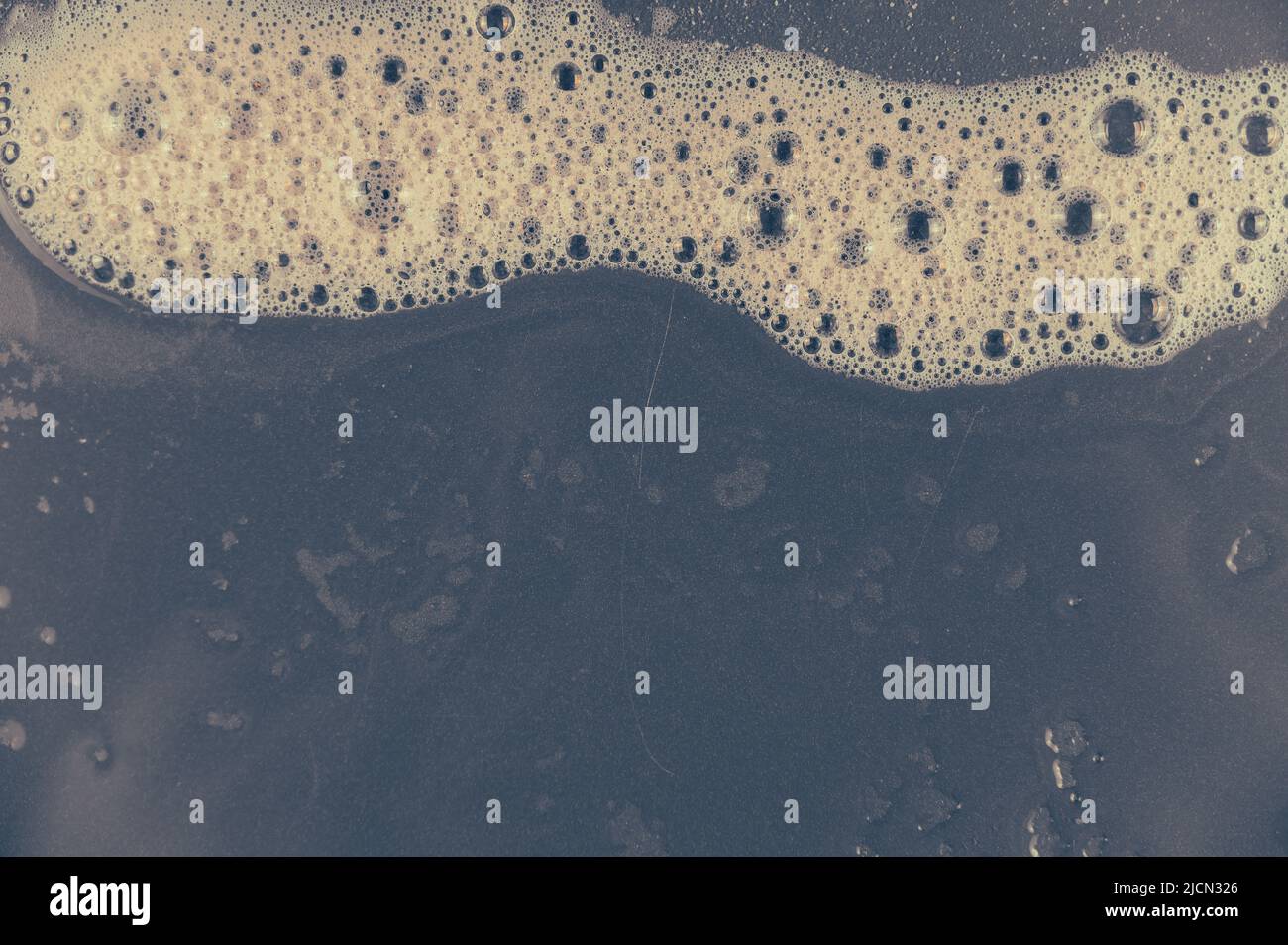 Soap foam against a gray background. Bubbles of white detergent foam ...