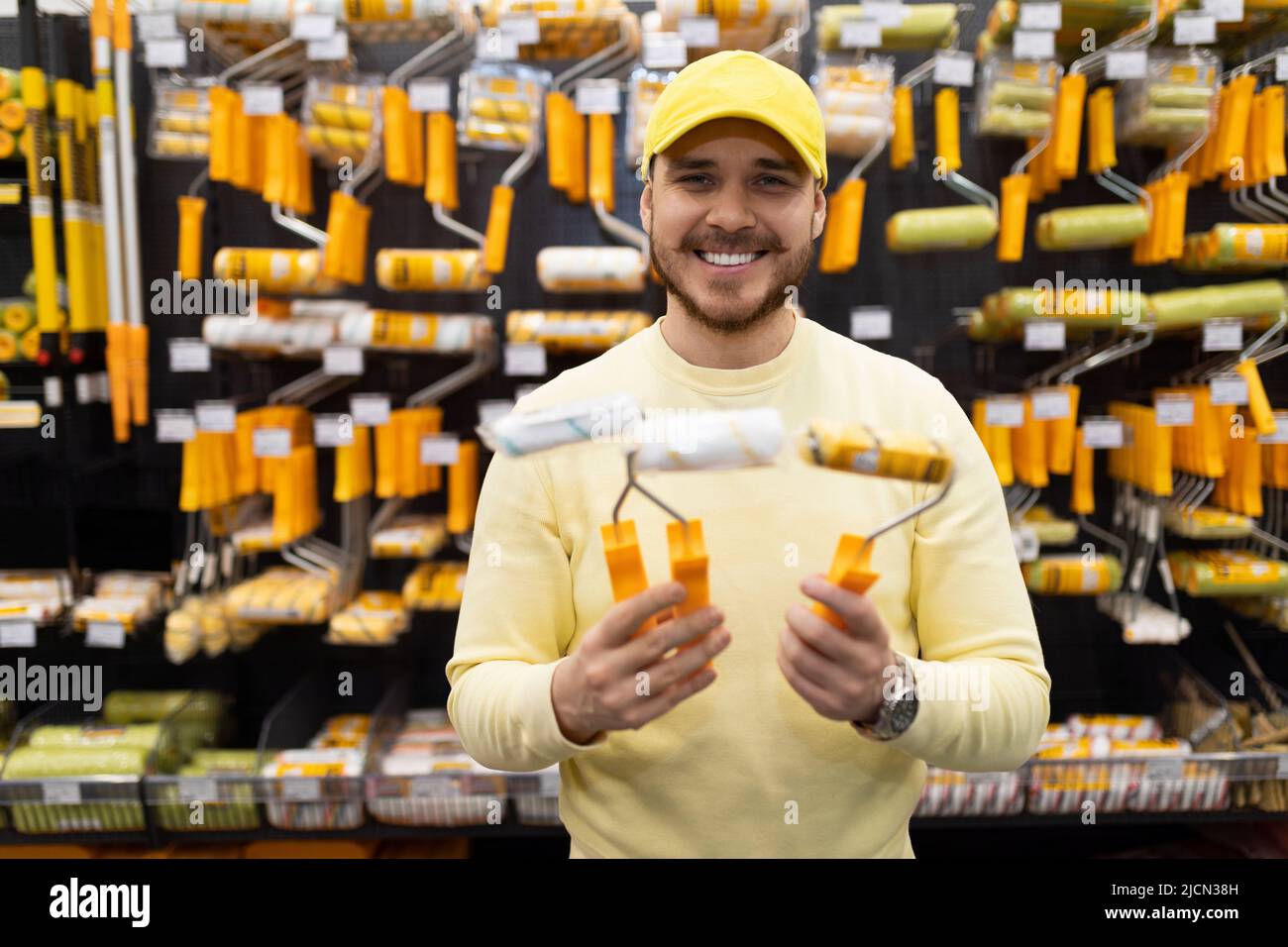 the sales assistant offers a choice of roller for painting work Stock ...