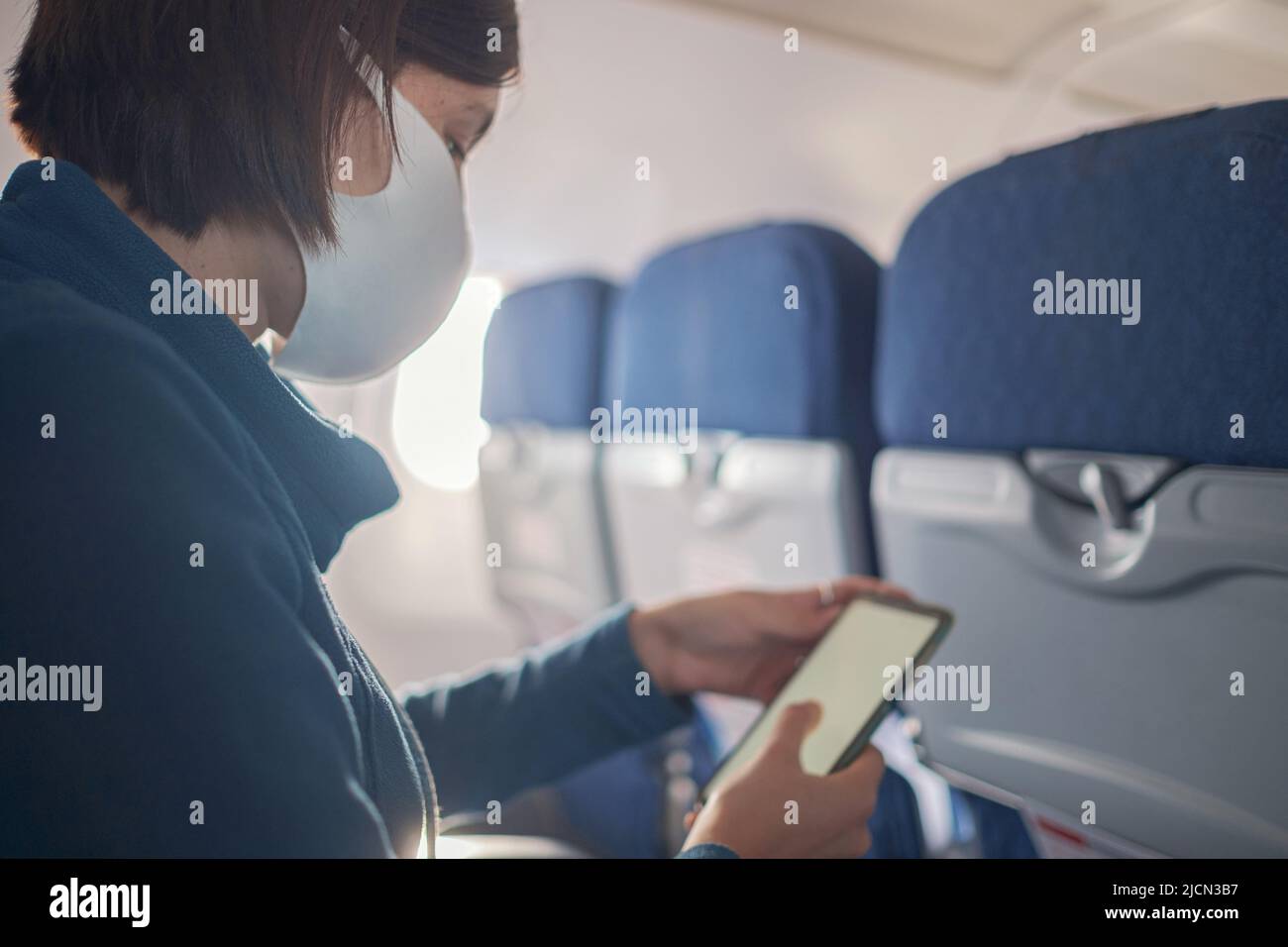 Young beautiful woman sitting at window of plane during the flight. new ...