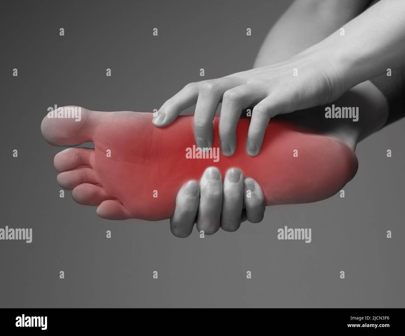 Foot pain. Hands holding leg with red point. Black and white ...