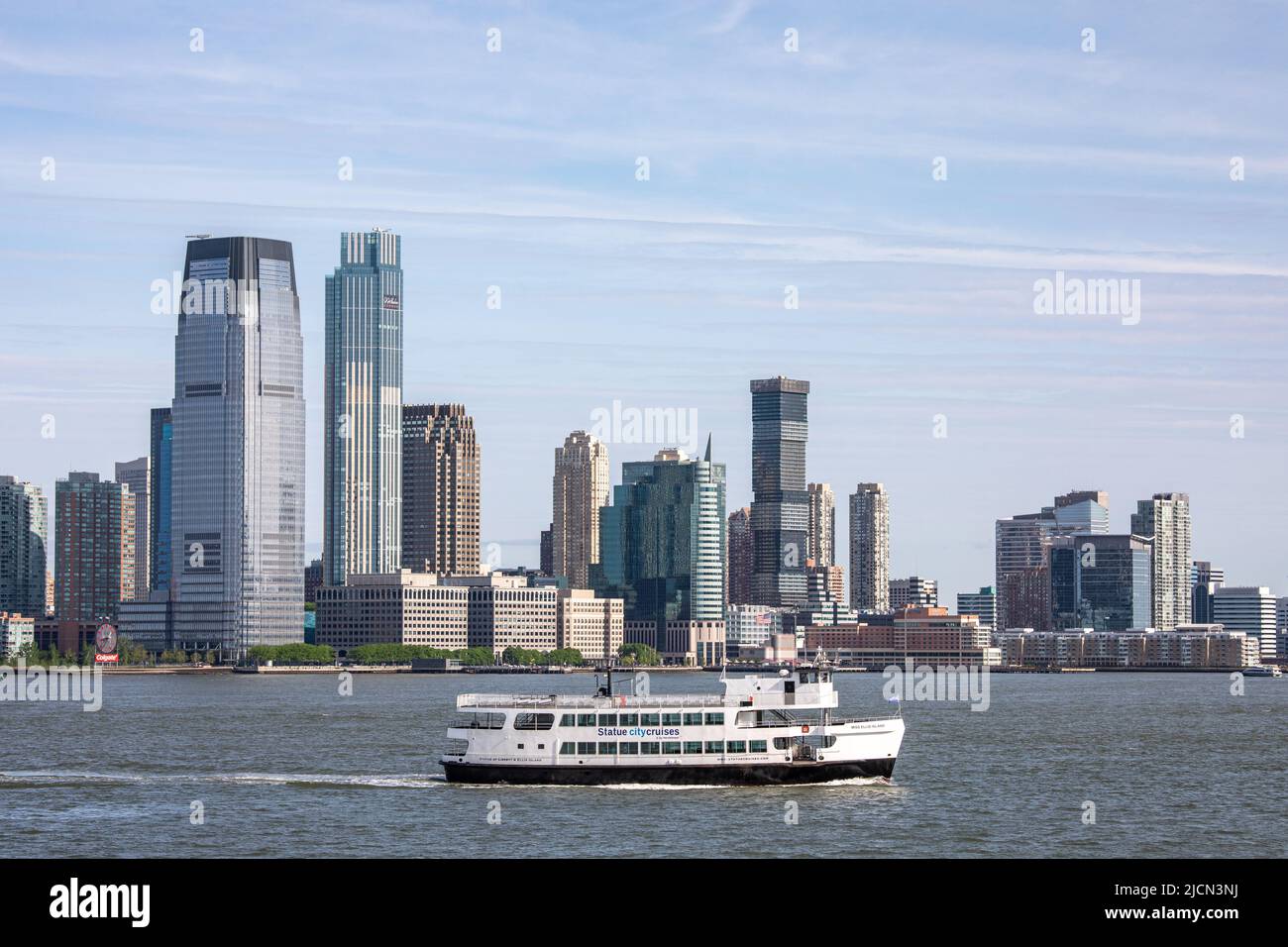 Miss Ellis Island of Statue City Cruises with Jersey City high-rise ...