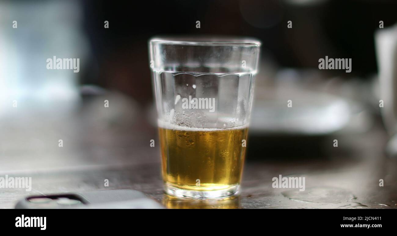 Hand close-up picking up glass beer at bar, person drinking alcoholic ...