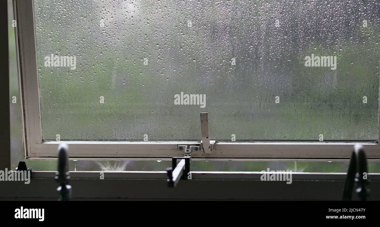 Rainy day outside window, window crack open with falling rain outdoors ...