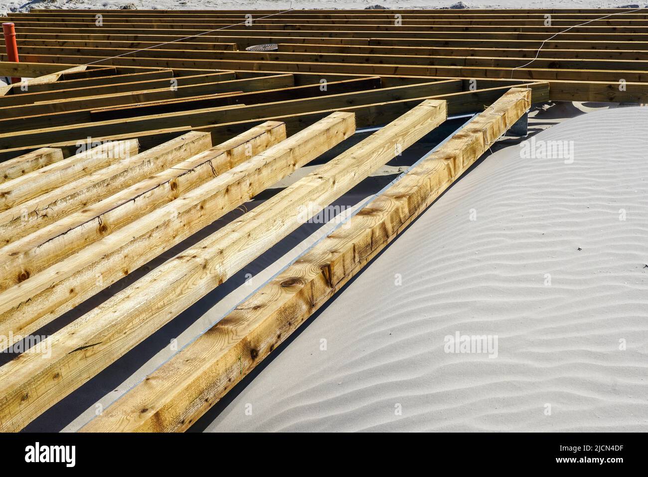 Construction of a new wooden board terrace on the sandy beach to ...