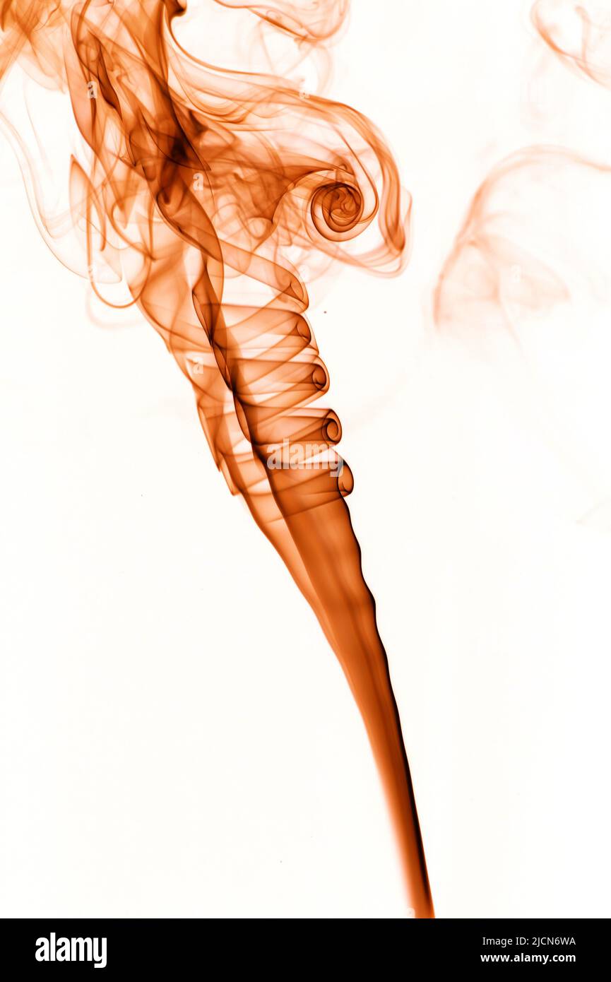 Puffs and curls of dark smoke on a white background rising from a ...