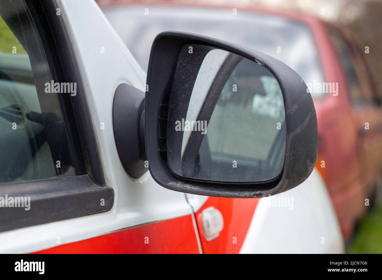 Side right black plastic rearview mirror on a white car. Exterior side ...