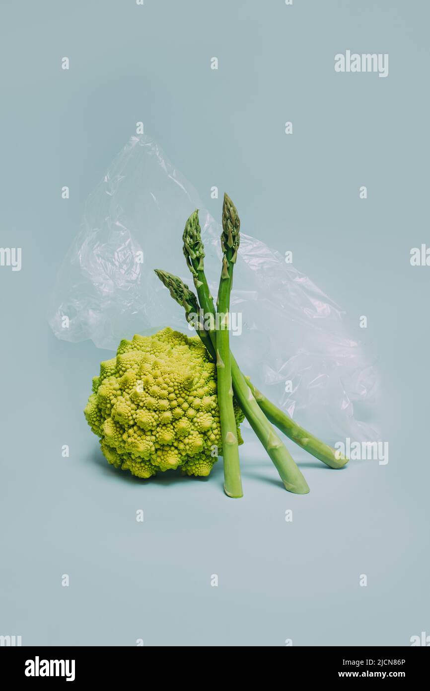 Fresh Asparagus and Romanesque cabbage on a blue pastel background ...