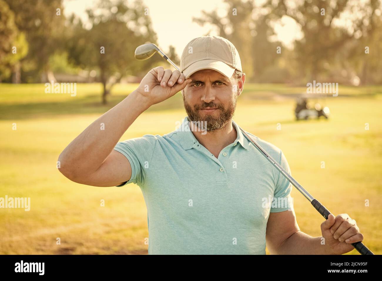 male golf player on professional golf course. portrait of golfer in cap ...