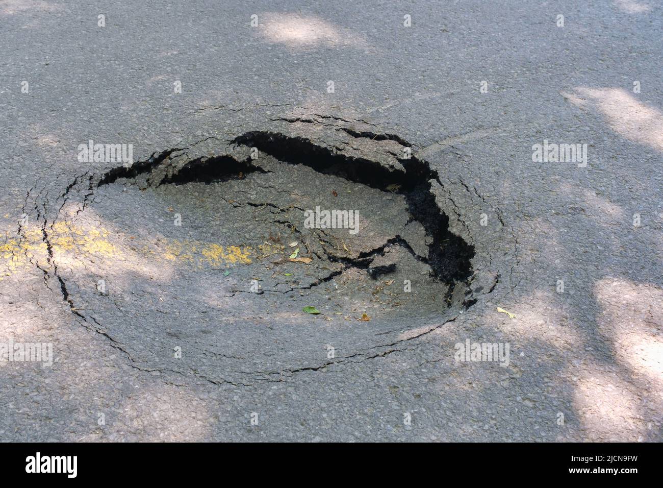 Large rounded pothole in Montreal with traffic cone Stock Photo - Alamy