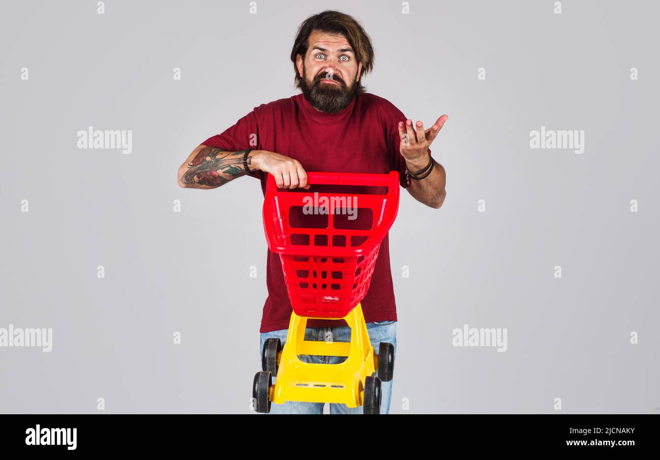 Confused bearded man with empty shopping cart. Male shopper in ...