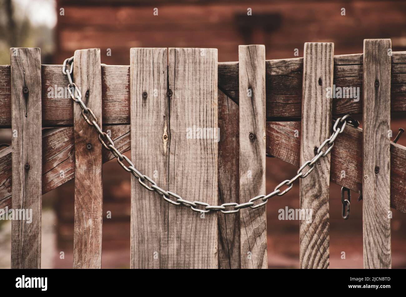 Old wooden gate closed with a rusty chain. Retro wood fence with ...